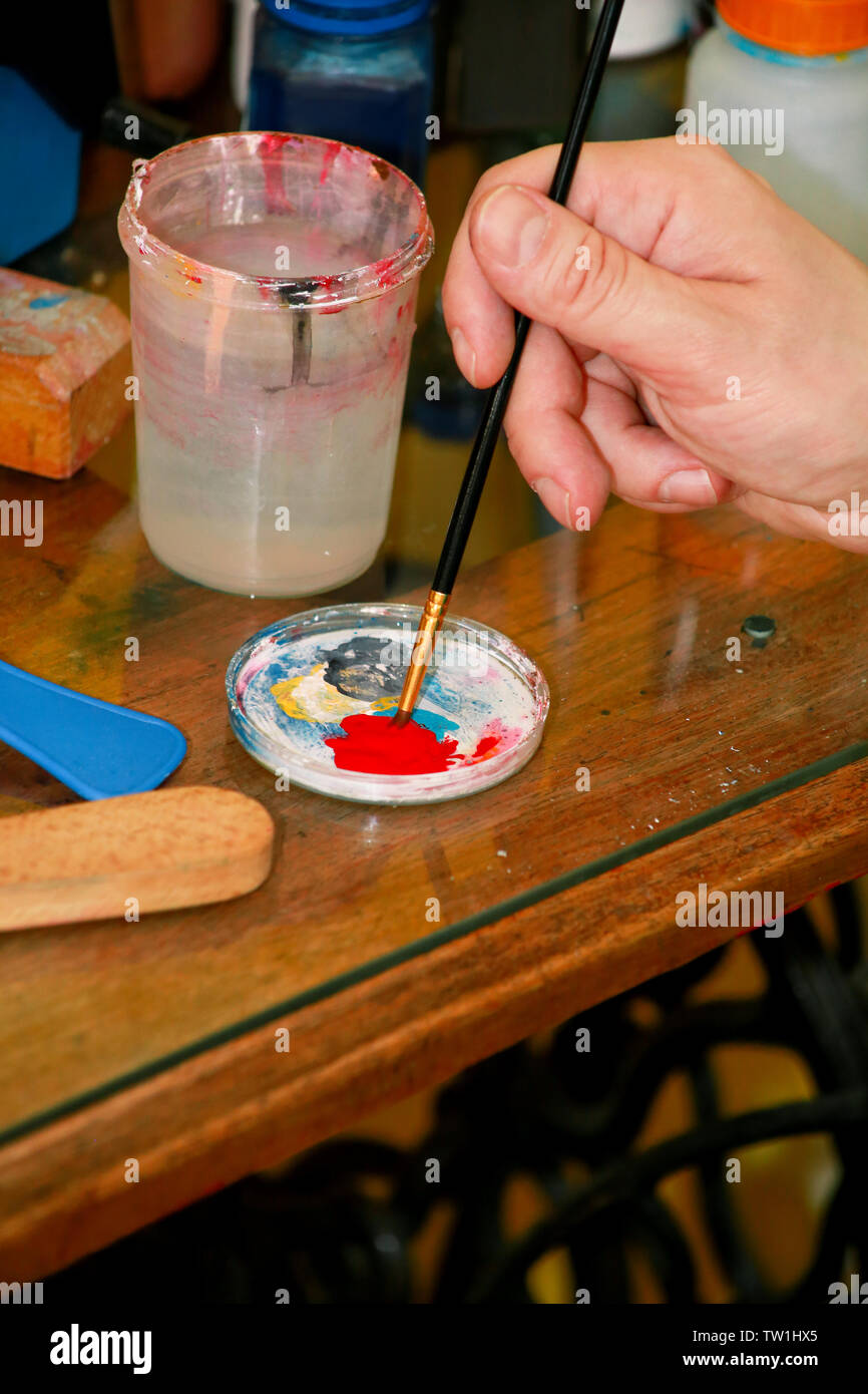 Man painter is mixing colors before painting at art paint studio ...