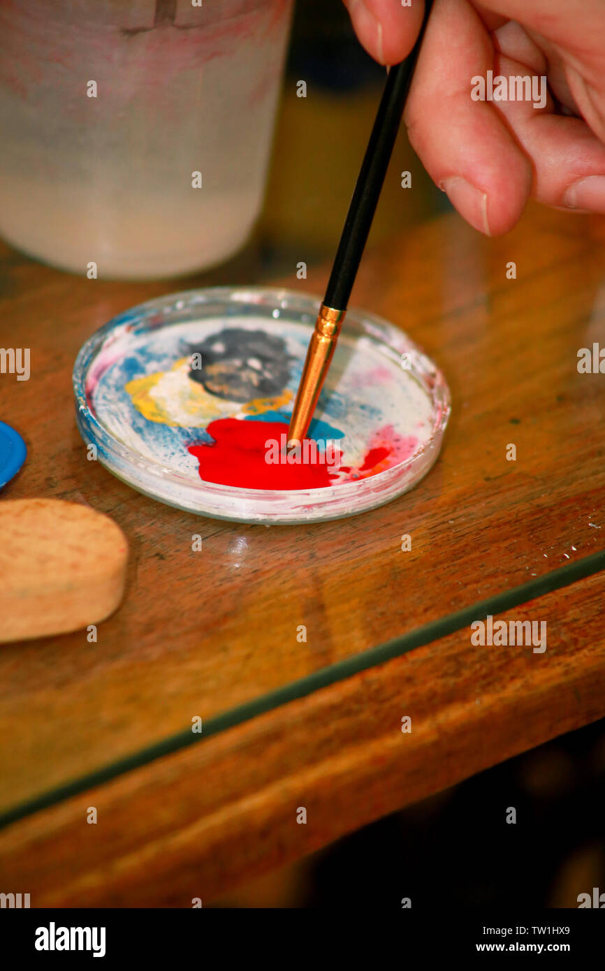 Man painter is mixing colors before painting at art paint studio ...