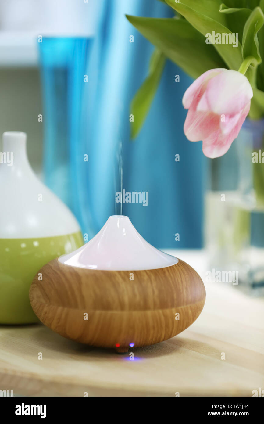 Aroma oil diffusers and flowers on table Stock Photo - Alamy