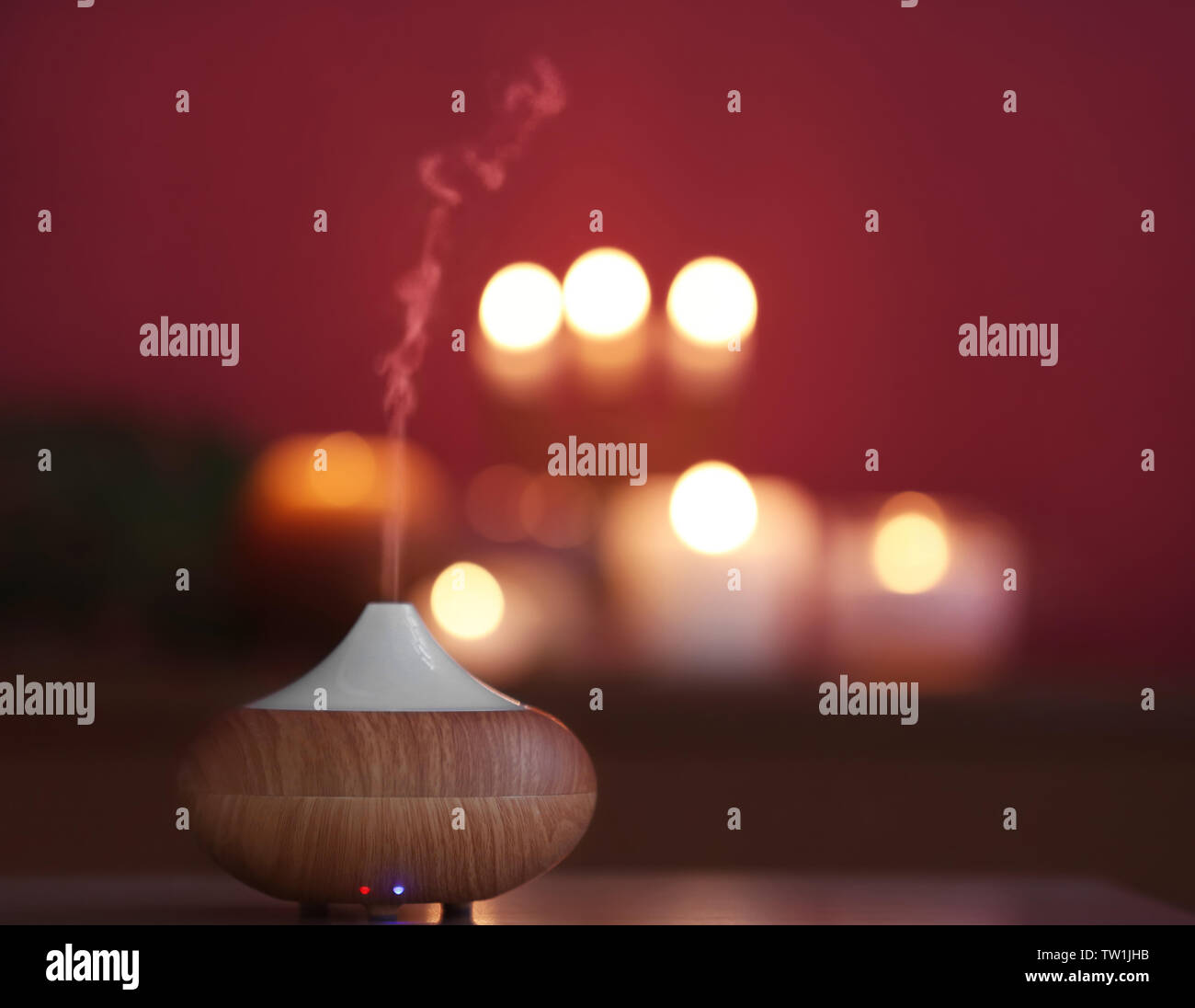 Aroma oil diffuser on blurred candlelight background Stock Photo - Alamy