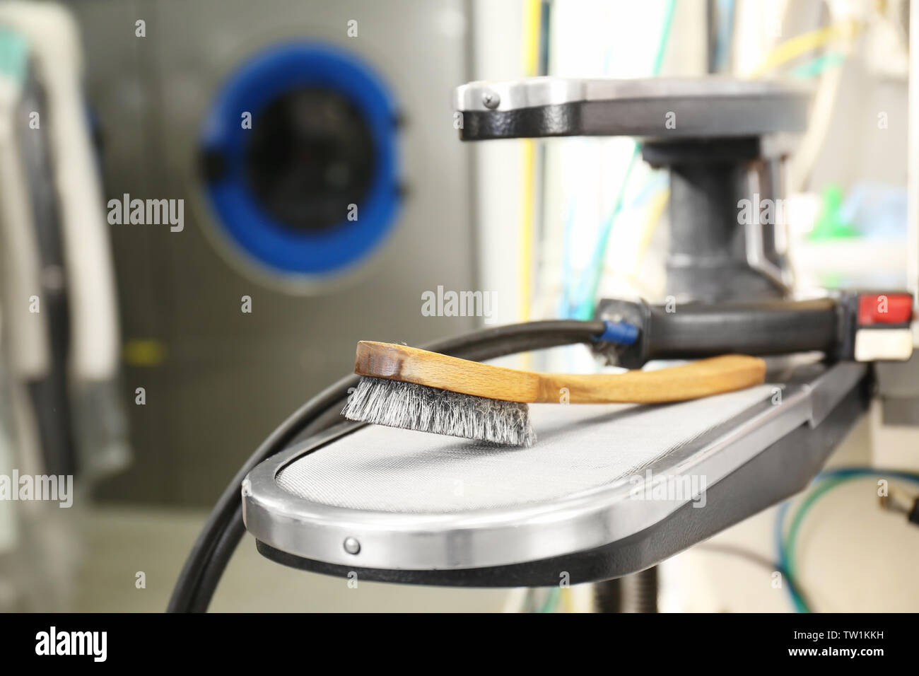 Steam spotting table with brush at dry-cleaning Stock Photo - Alamy