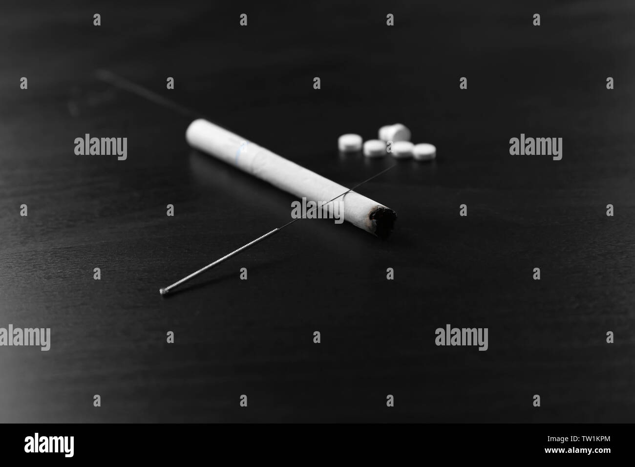 Acupuncture needles with cigarette on dark background Stock Photo - Alamy