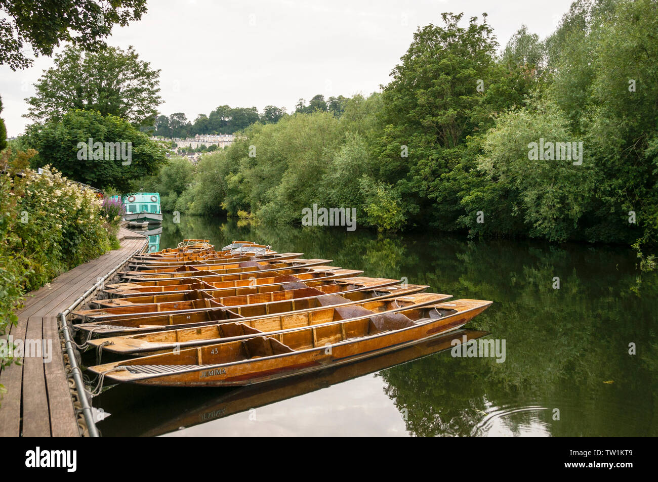 Wooden punts, houseboats and boardwalk on the River Avon in Bath ...