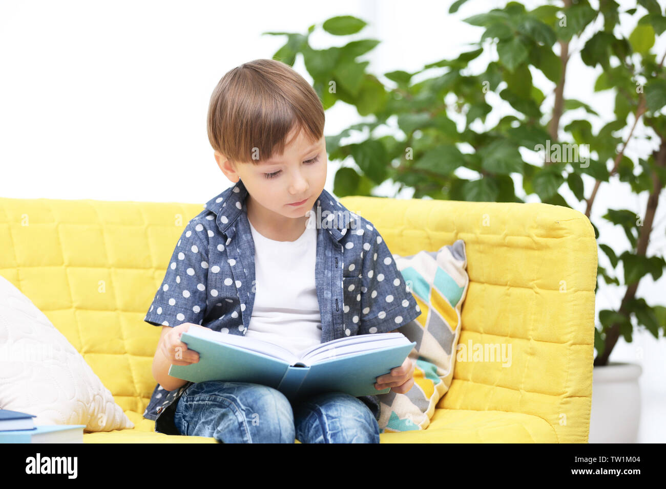 Cute little boy reading book at home Stock Photo - Alamy