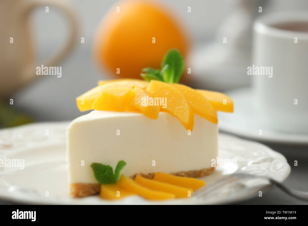 Tasty cheesecake slice with fruit on plate Stock Photo - Alamy