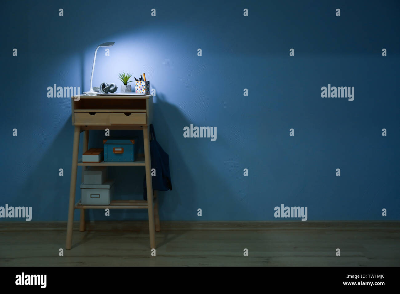 High modern workplace with lighted table in dark room Stock Photo - Alamy