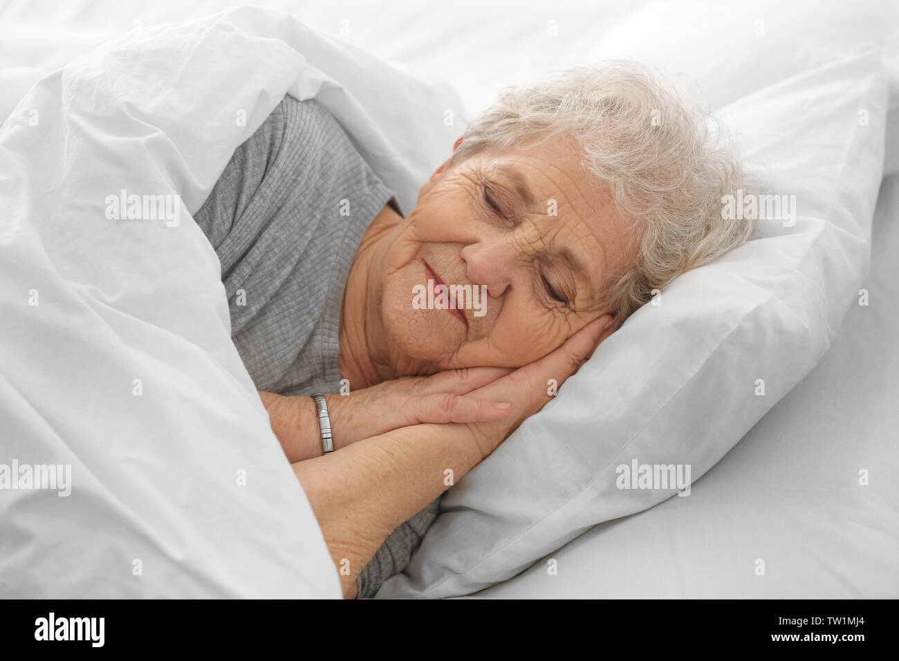 Elderly woman sleeping in bed Stock Photo - Alamy