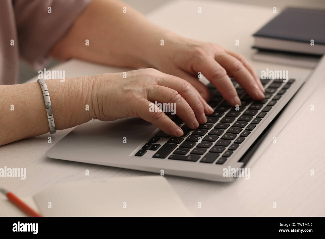 Hands of elderly woman working on laptop Stock Photo - Alamy