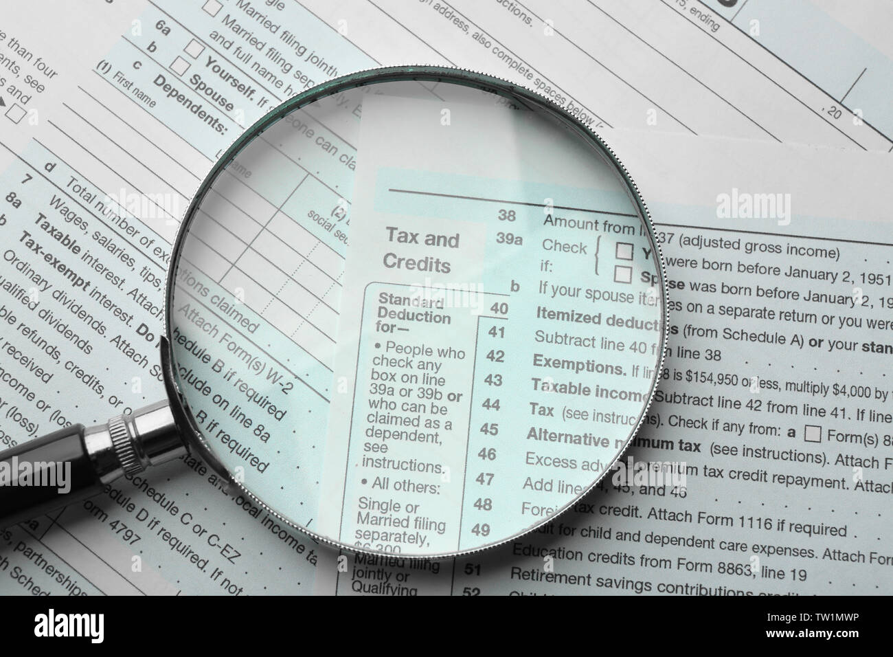 Income tax return form with magnifying glass Stock Photo - Alamy