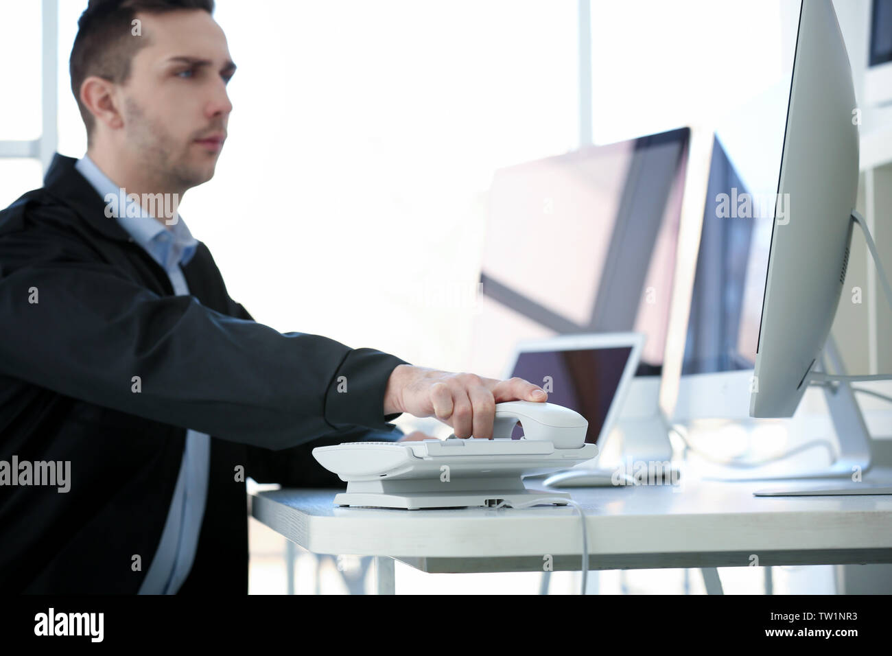 Handsome security guard using telephone in surveillance room Stock ...