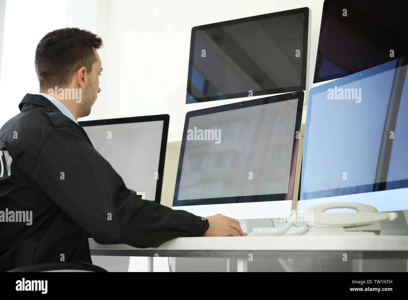 Handsome security guard in surveillance room Stock Photo - Alamy