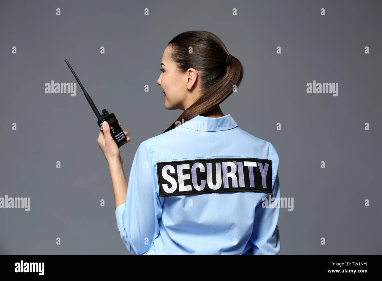 Beautiful security guard on grey background Stock Photo - Alamy