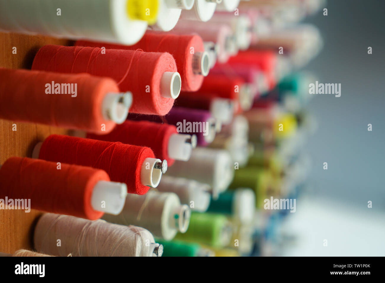 Spools with colorful threads on rack, closeup Stock Photo - Alamy