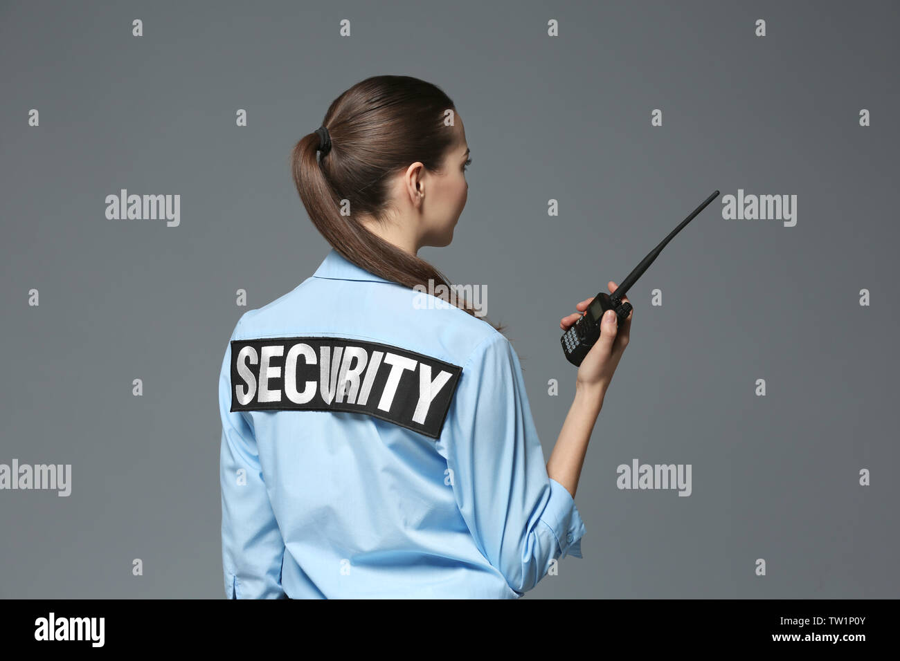 Beautiful security guard on grey background Stock Photo - Alamy