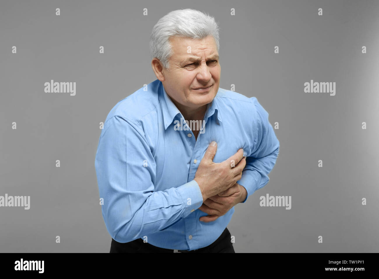 Man with chest pain suffering from heart attack on grey background ...
