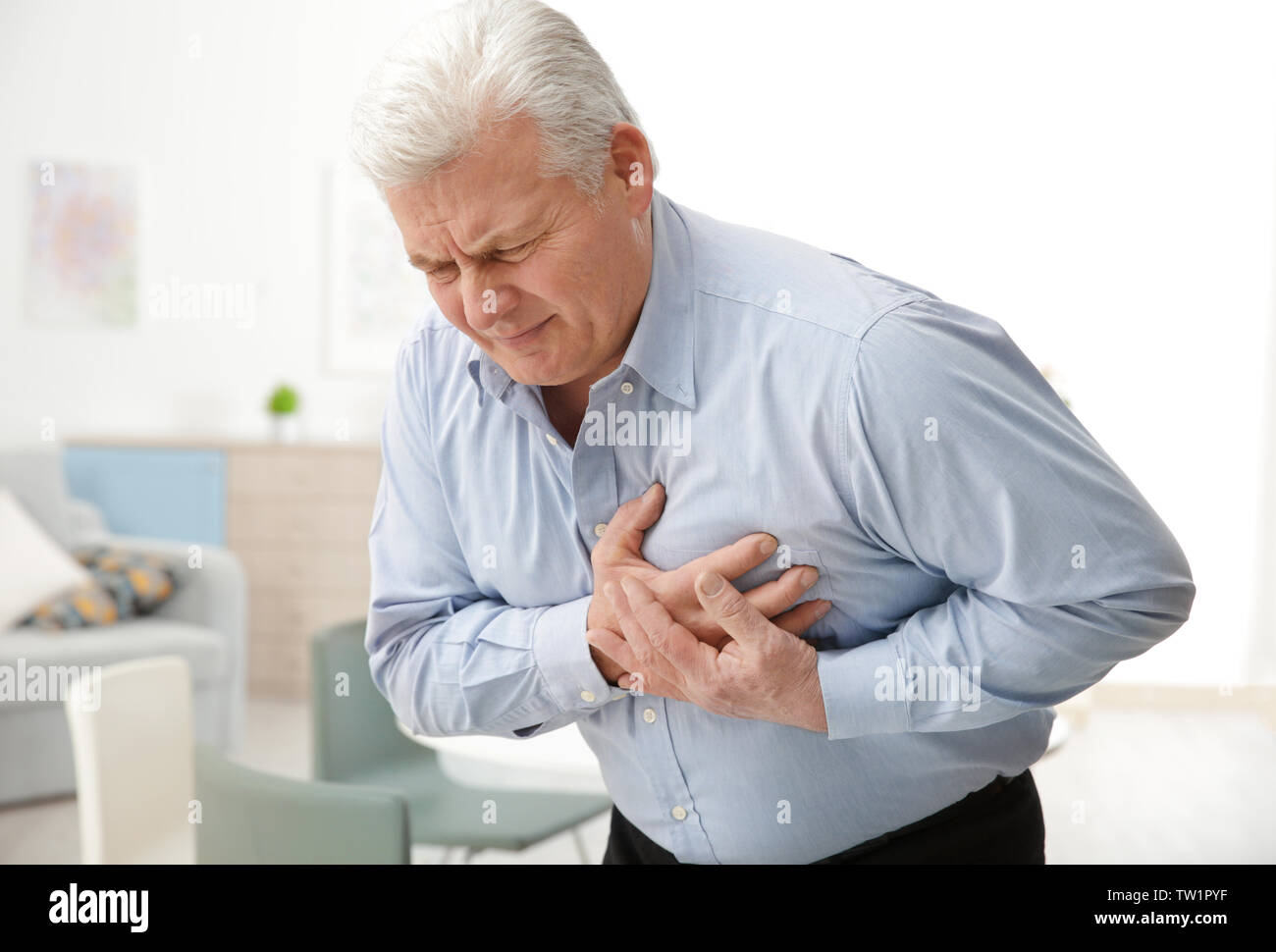 Man with chest pain suffering from heart attack in office Stock Photo ...