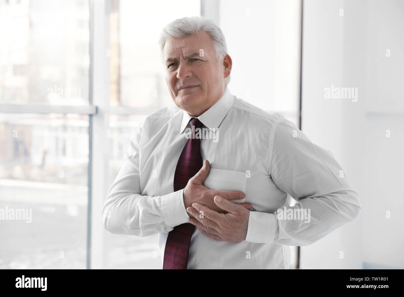 Man with chest pain suffering from heart attack in office Stock Photo ...