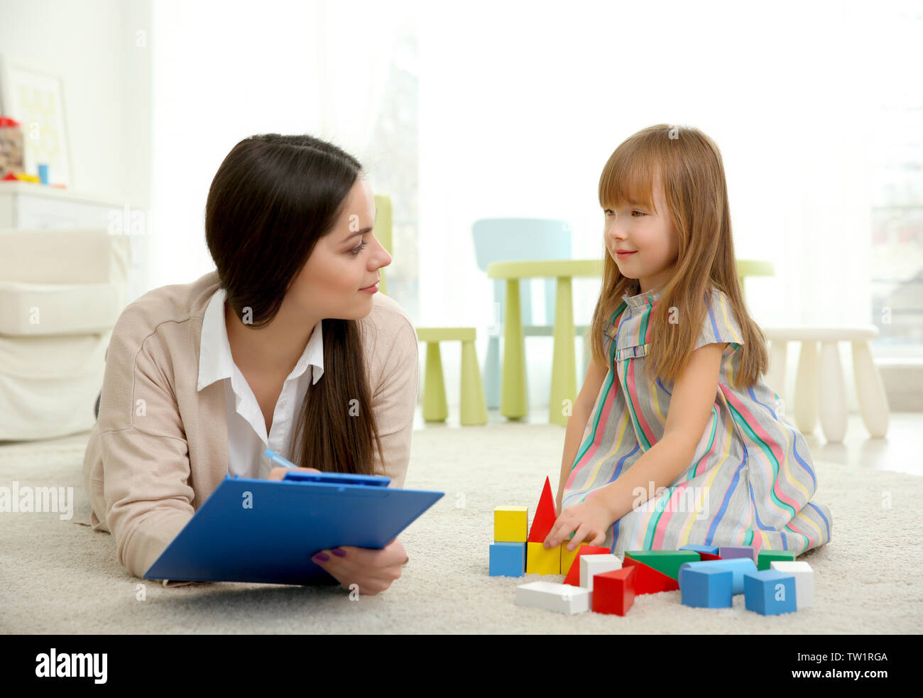 Young child psychologist working with little girl Stock Photo - Alamy