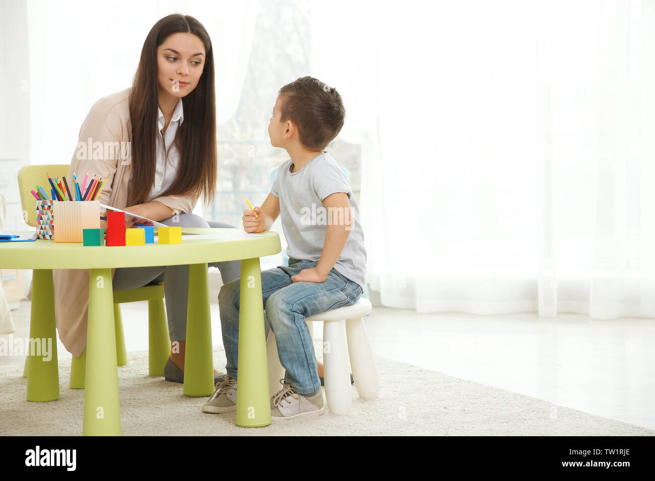 Young child psychologist working with little boy Stock Photo - Alamy