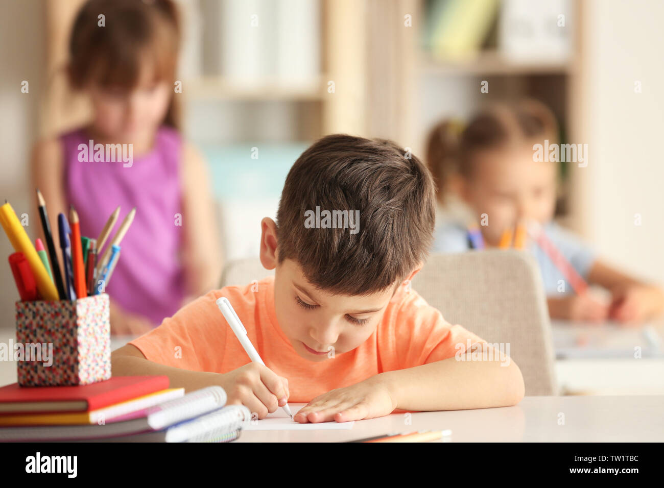 Cute boy drawing in classroom Stock Photo - Alamy