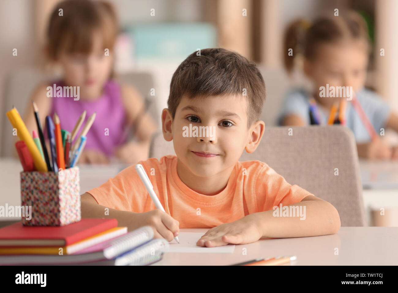 Cute boy drawing in classroom Stock Photo - Alamy