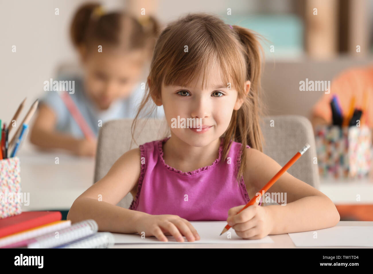 Cute girl drawing in classroom Stock Photo - Alamy