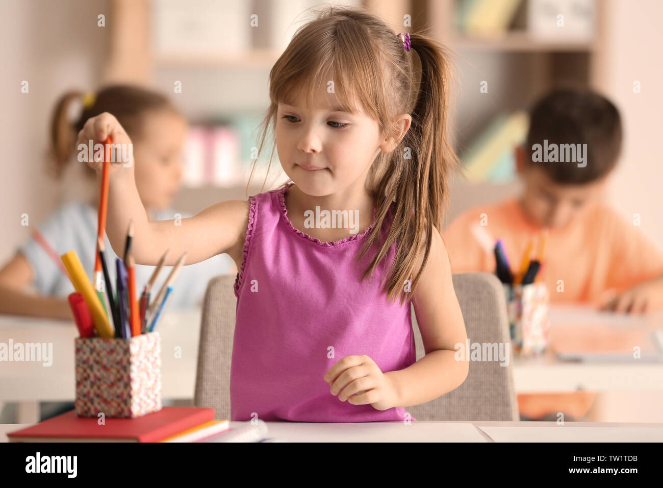 Cute girl at drawing lesson in classroom Stock Photo - Alamy