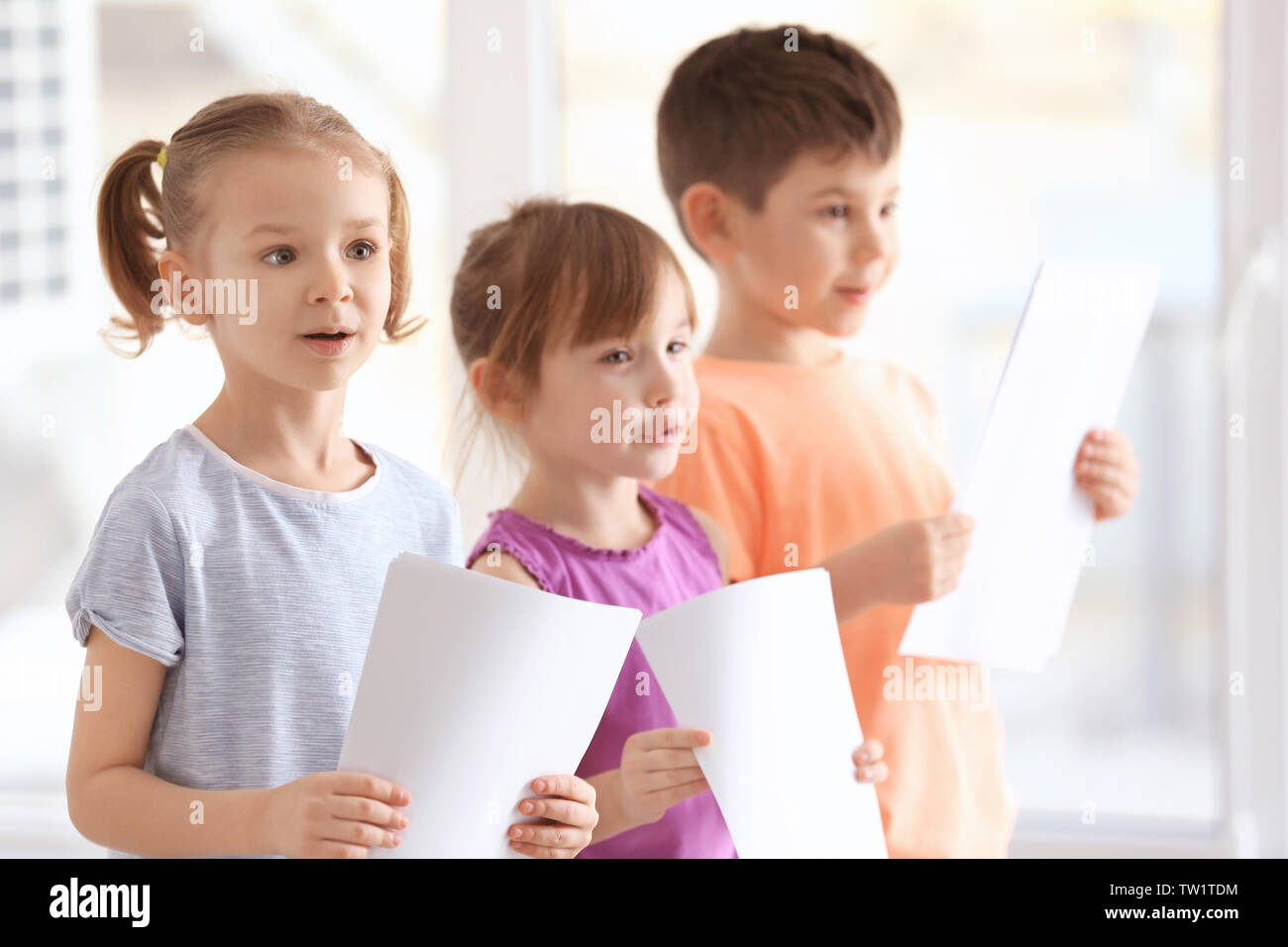 Cute kids singing in music class Stock Photo - Alamy