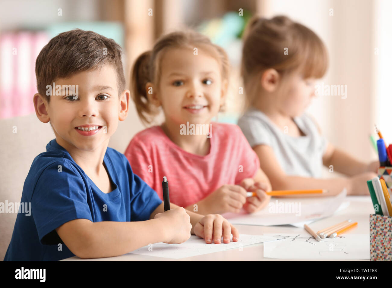 Cute kids drawing in classroom Stock Photo - Alamy