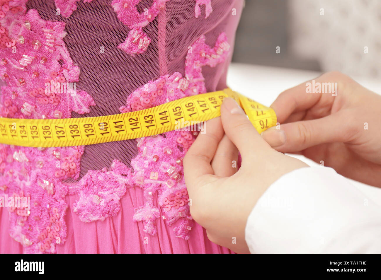 Woman checking measurement of evening dress at fashion atelier Stock ...