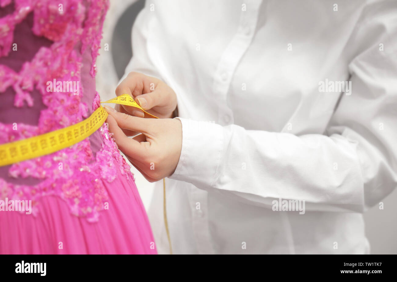 Woman checking measurement of evening dress at fashion atelier Stock ...