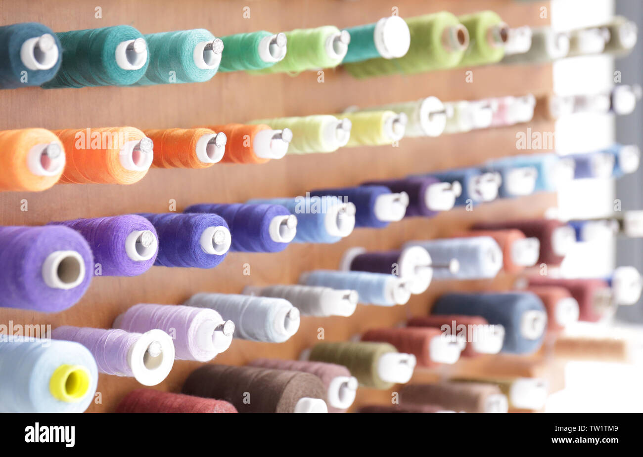 Spools with threads on rack, closeup Stock Photo - Alamy