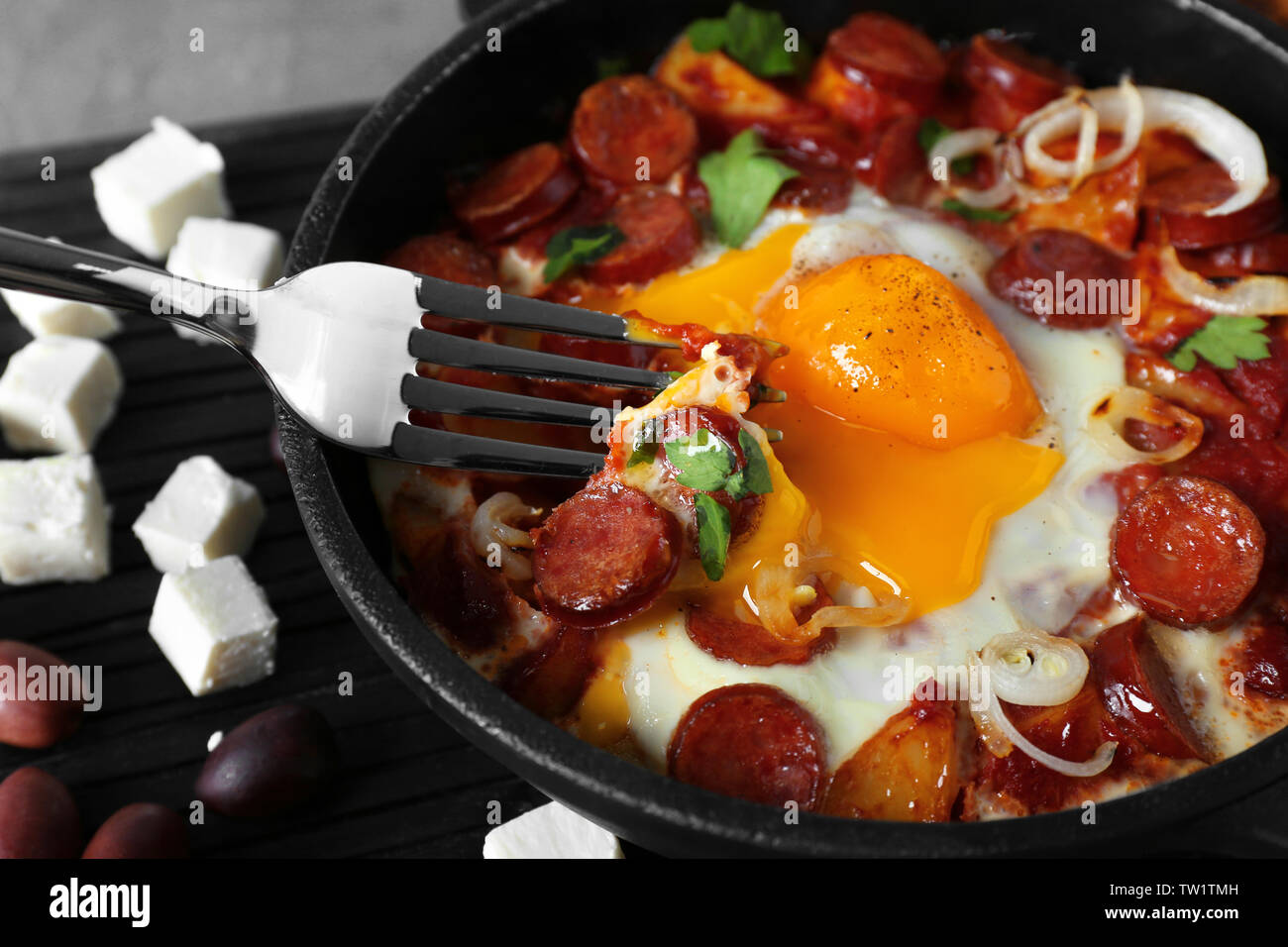 Tasty cooked egg with sausages in frying pan Stock Photo - Alamy