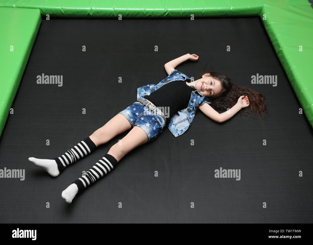 Cute girl playing on trampoline Stock Photo - Alamy