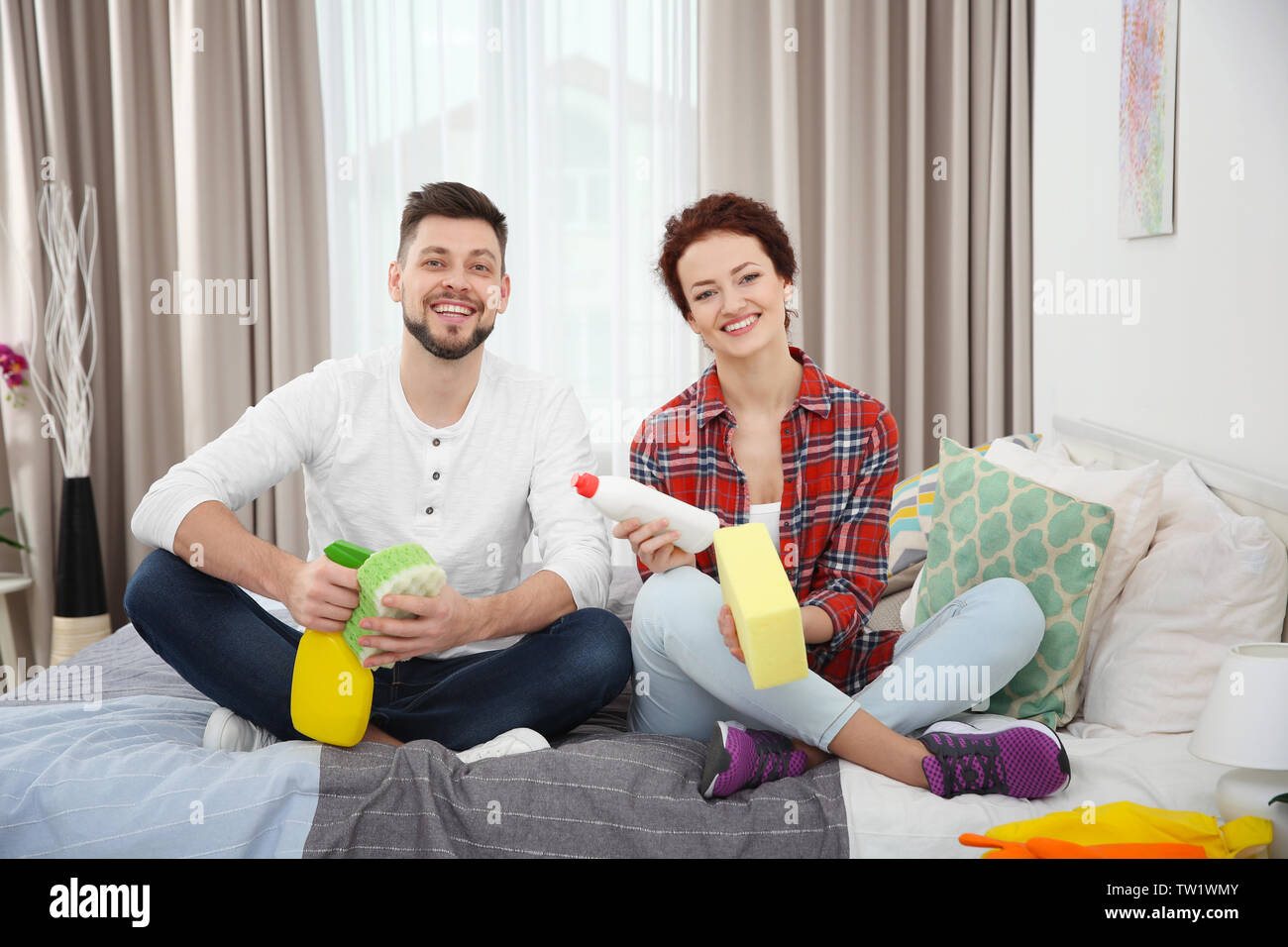 Happy young couple cleaning home together Stock Photo - Alamy