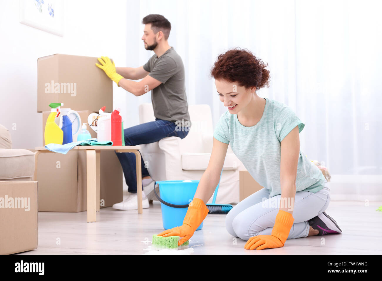 Happy young couple cleaning home together Stock Photo - Alamy