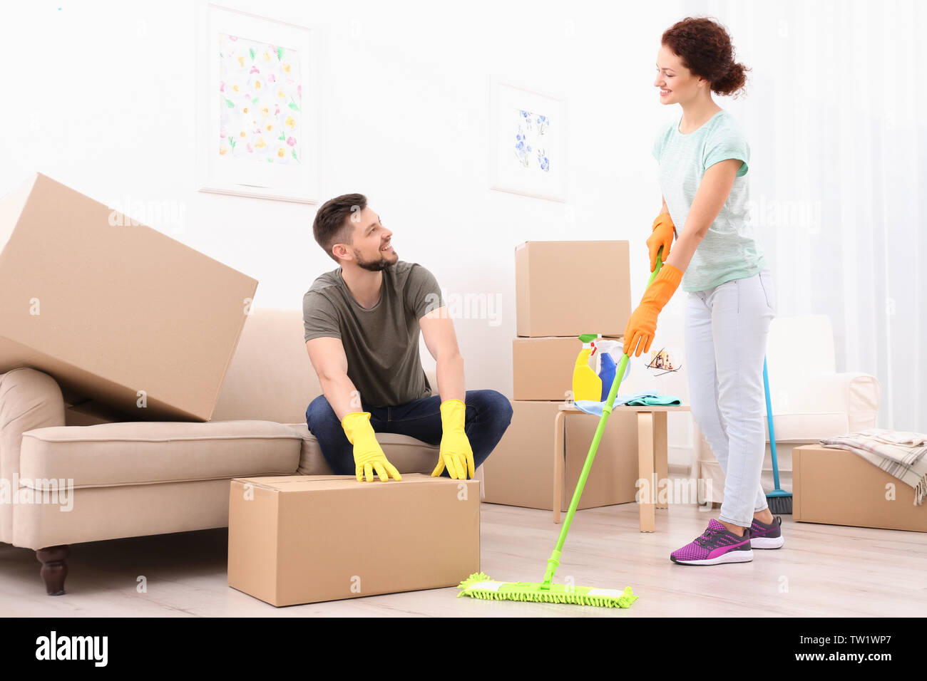 Happy young couple cleaning home together Stock Photo - Alamy