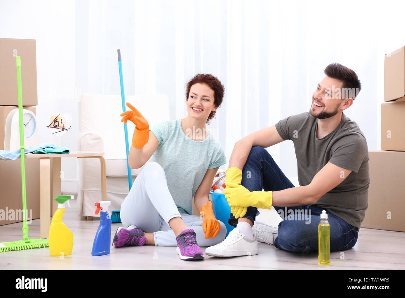 Happy young couple cleaning home together Stock Photo - Alamy
