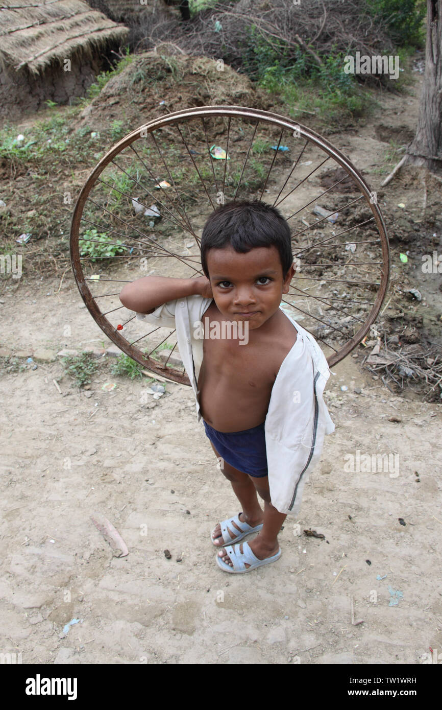 High angle view of a boy carrying tyre rim, India Stock Photo - Alamy