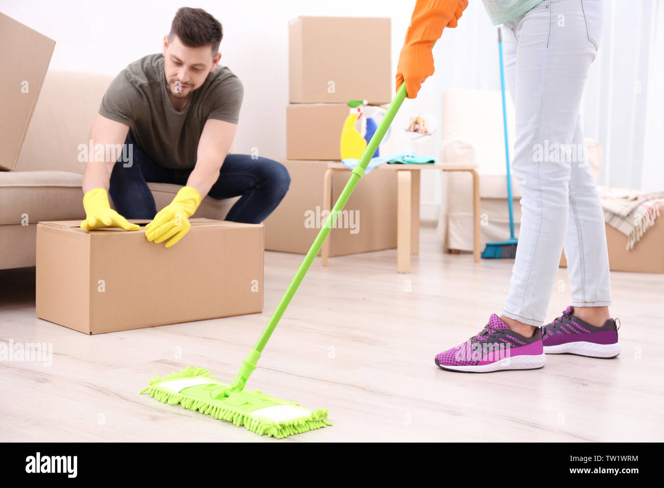 Happy young couple cleaning home together Stock Photo - Alamy