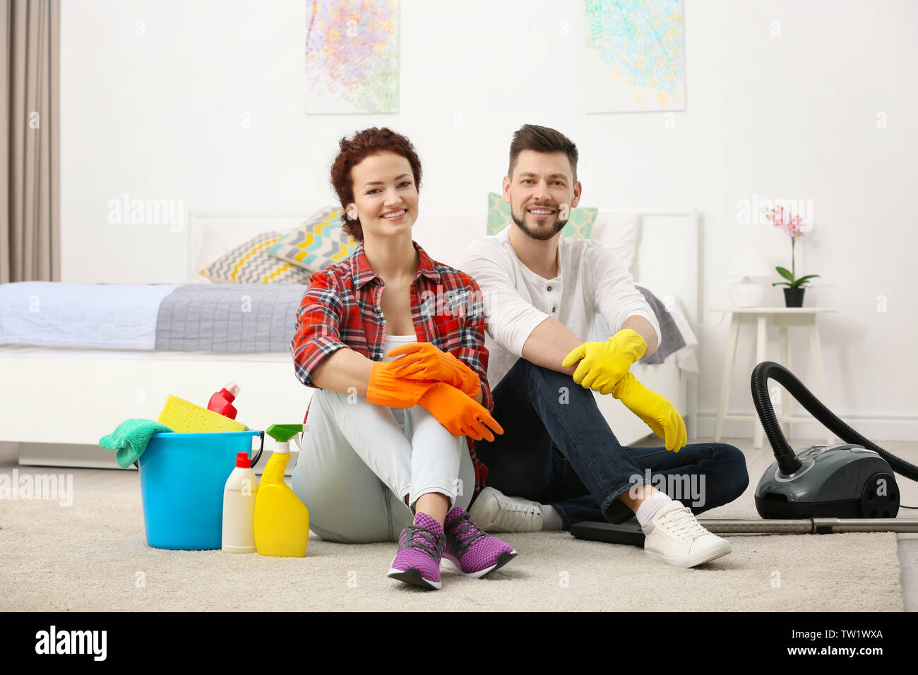 Happy young couple cleaning home together Stock Photo - Alamy
