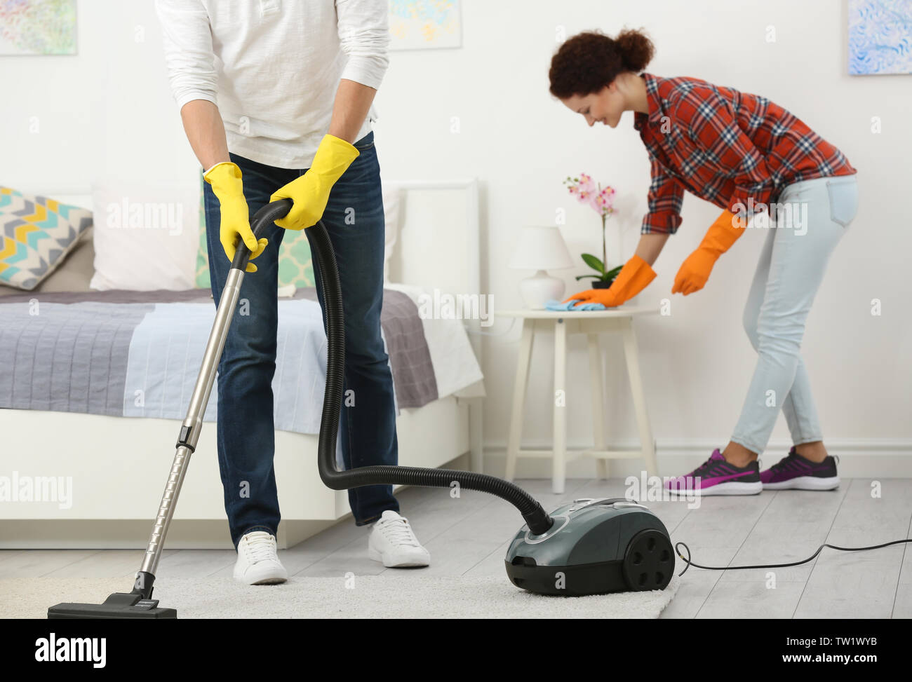 Happy young couple cleaning home together Stock Photo - Alamy