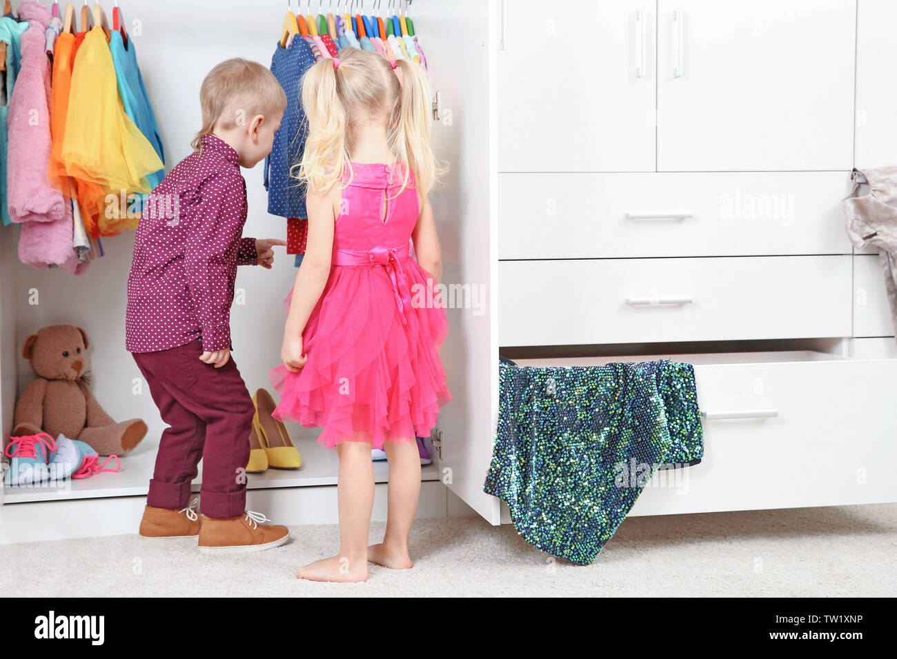 Cute small kids playing in wardrobe Stock Photo - Alamy