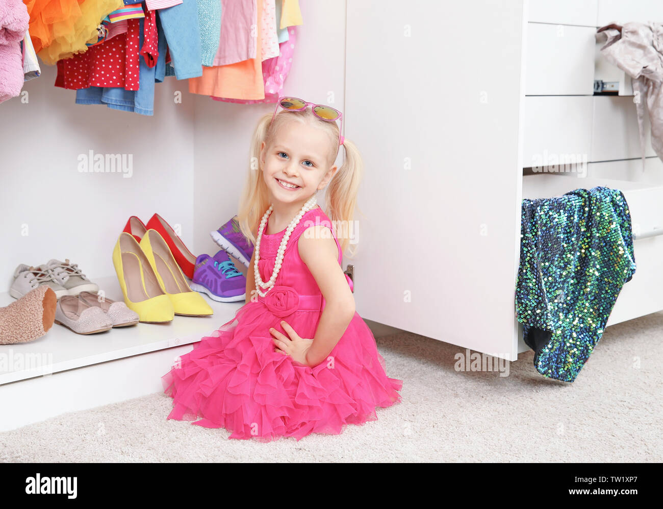 Cute small girl in wardrobe with clothes Stock Photo - Alamy