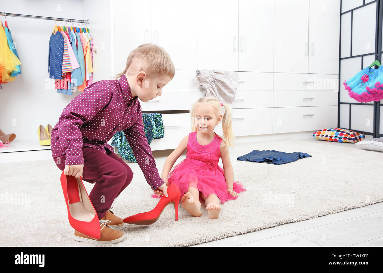 Cute small kids playing in wardrobe Stock Photo - Alamy