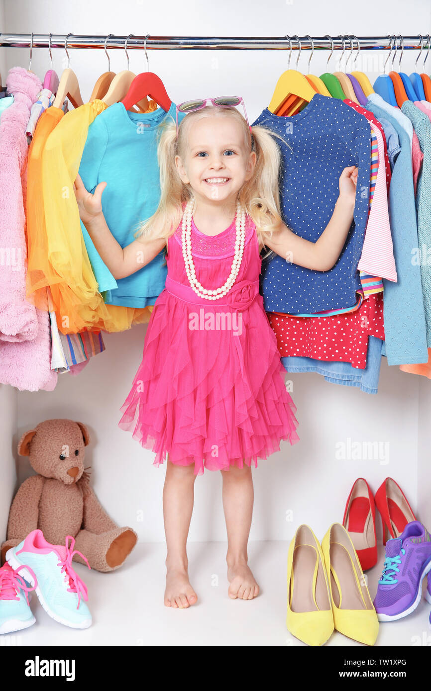 Cute small girl in wardrobe with clothes Stock Photo - Alamy
