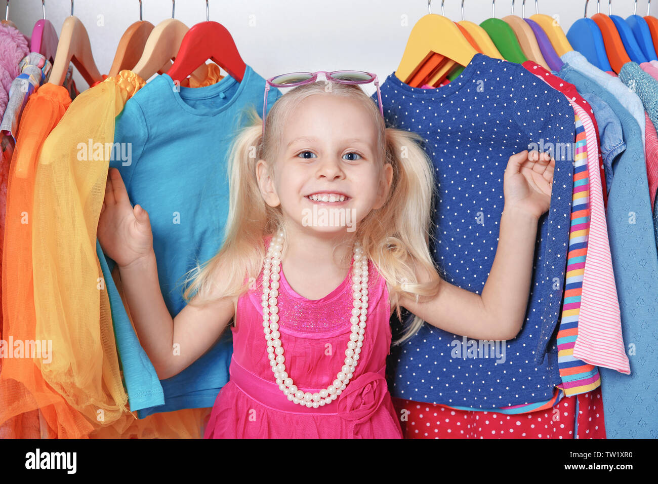 Cute small girl in wardrobe with clothes Stock Photo - Alamy