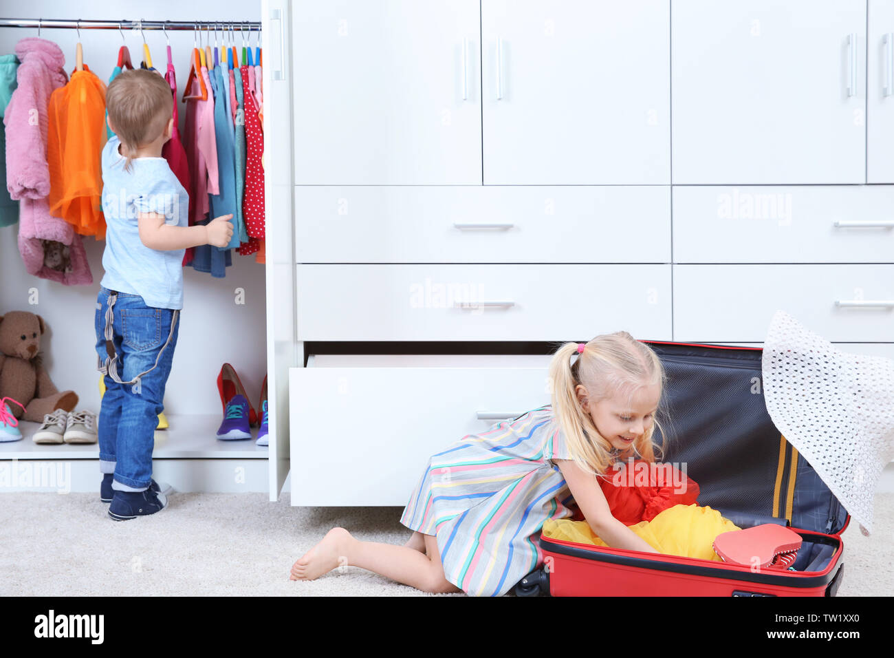 Cute small kids playing in wardrobe Stock Photo - Alamy