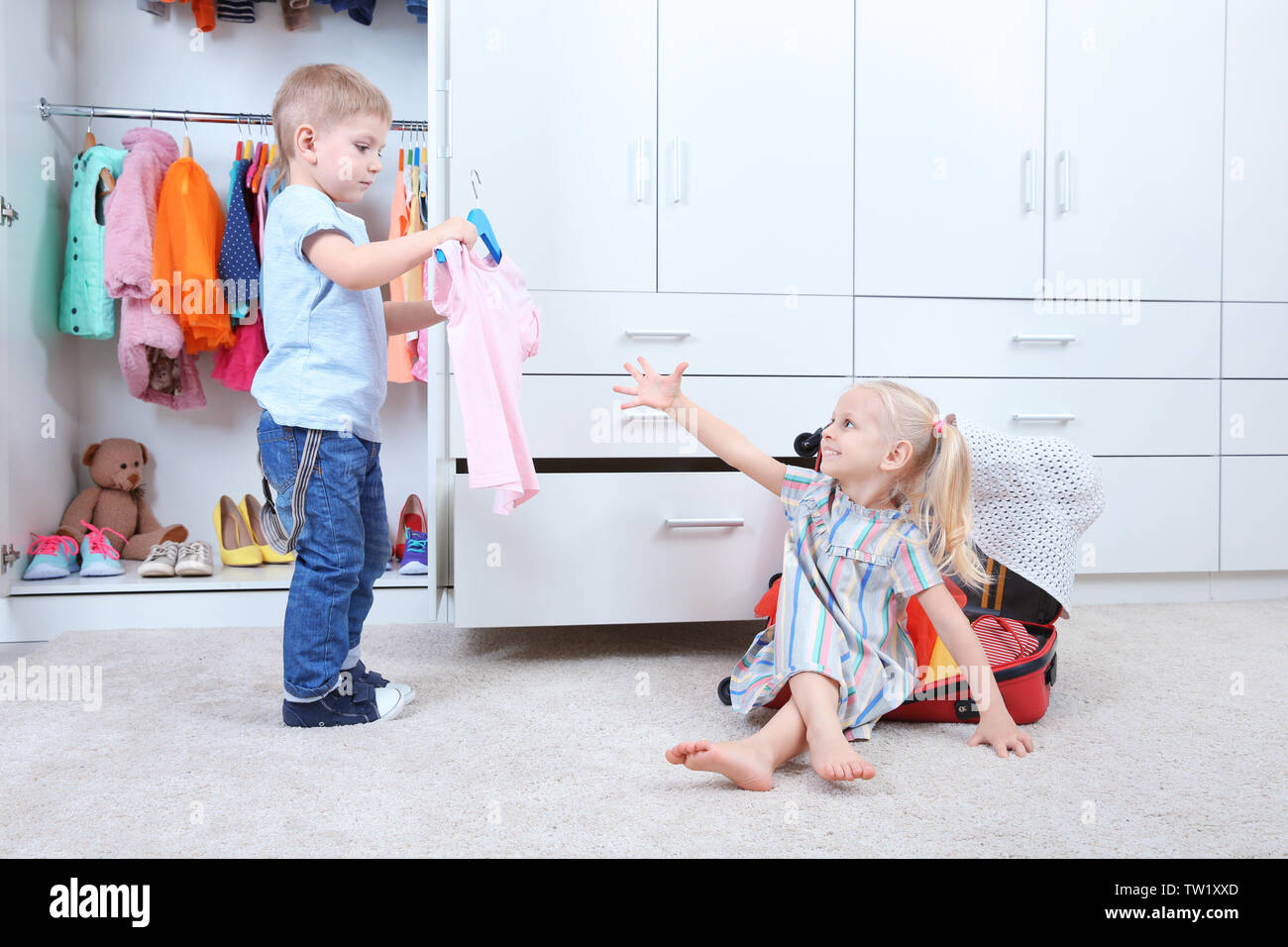 Cute small kids playing in wardrobe Stock Photo - Alamy