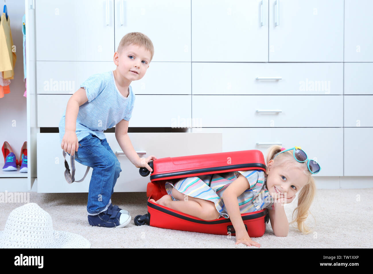 Cute small kids playing in wardrobe Stock Photo - Alamy